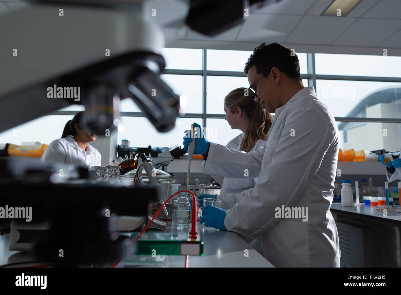Team of scientists experimenting together Stock Photo - Alamy