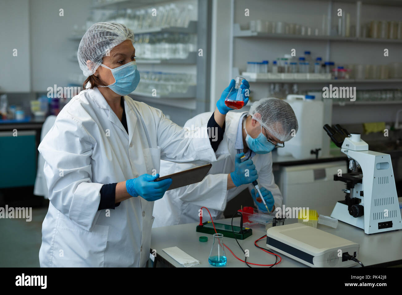 Scientists experimenting in laboratory Stock Photo - Alamy