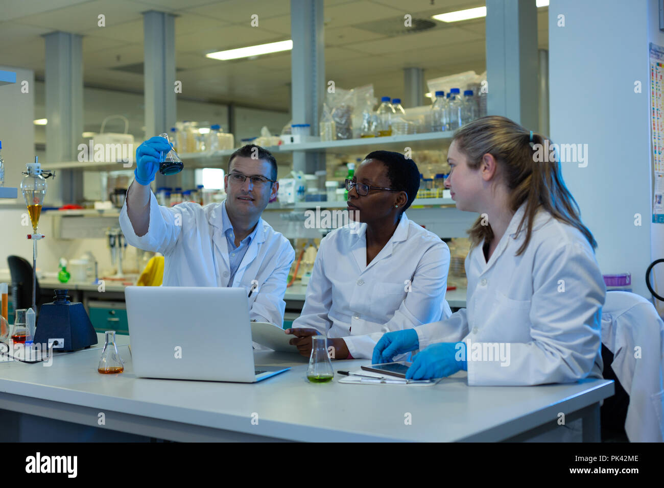 Team of scientists experimenting together Stock Photo - Alamy