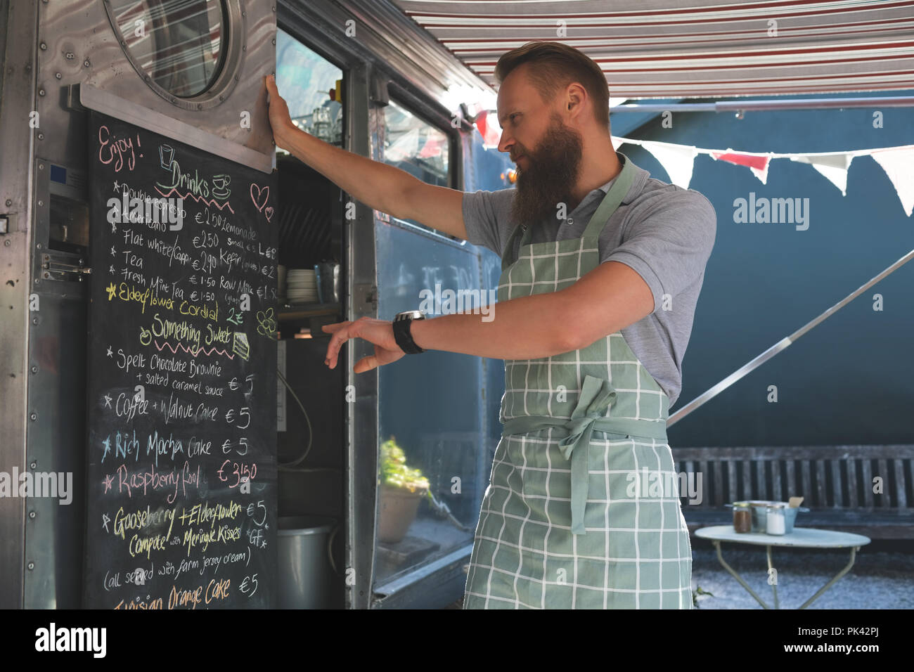 Male waiter looking at menu board Stock Photo - Alamy