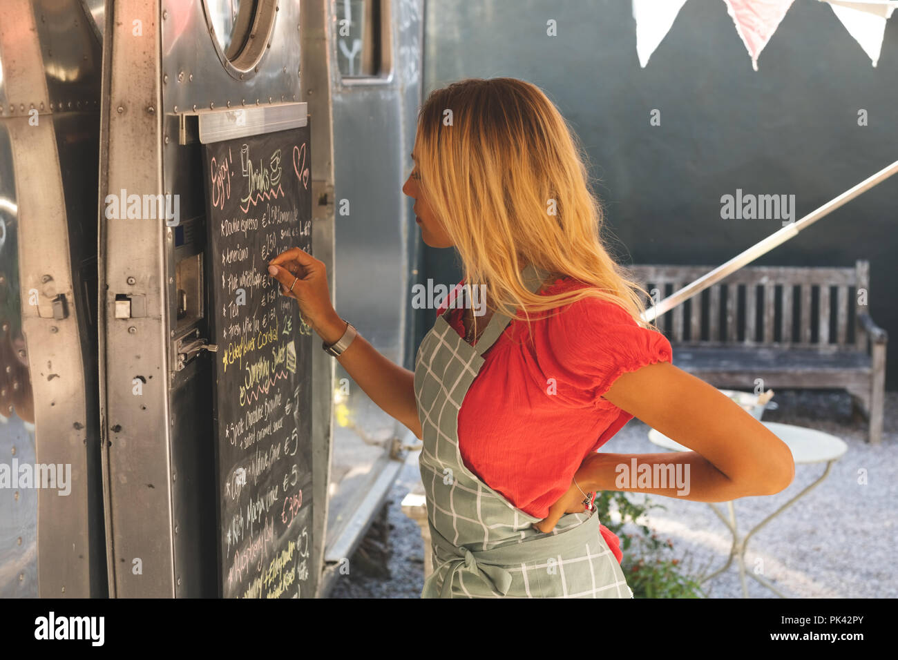 Female waitress writing menu on menu board Stock Photo - Alamy