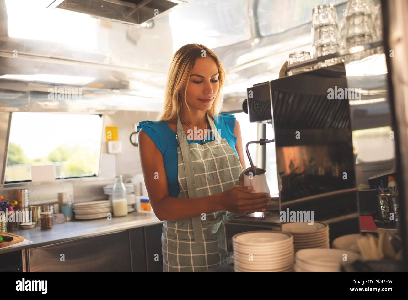 Female waiter preparing coffee in food truck Stock Photo - Alamy