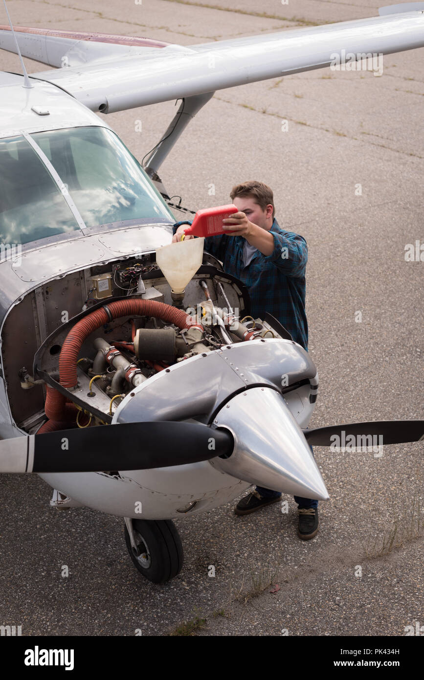 Engineer filling oil in aircraft engine Stock Photo - Alamy