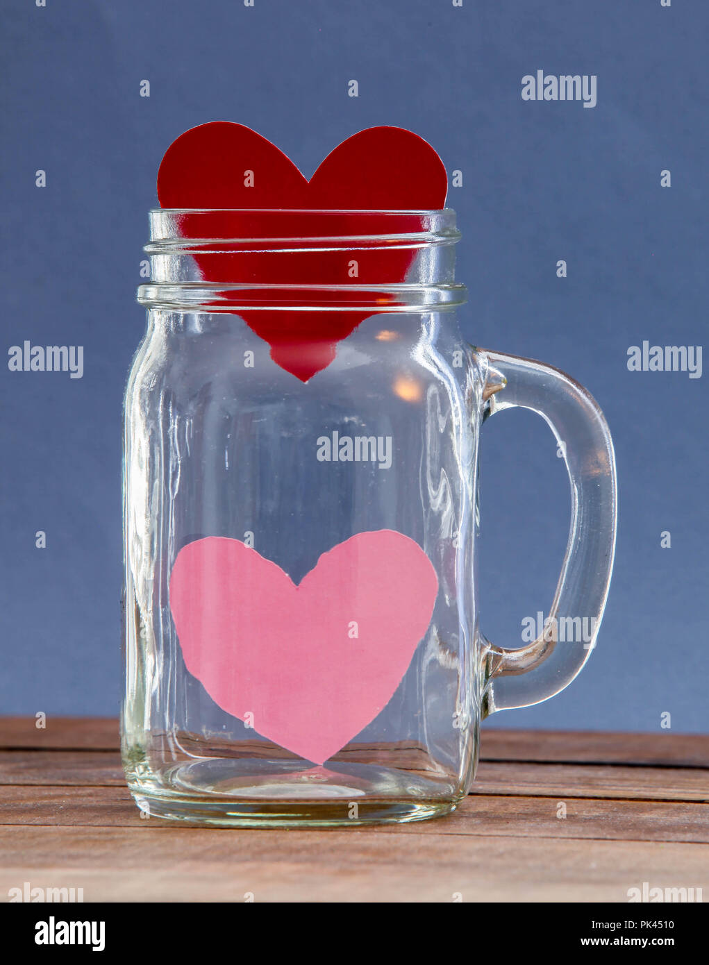 Two paper hearts inside jar with blue background Stock Photo - Alamy