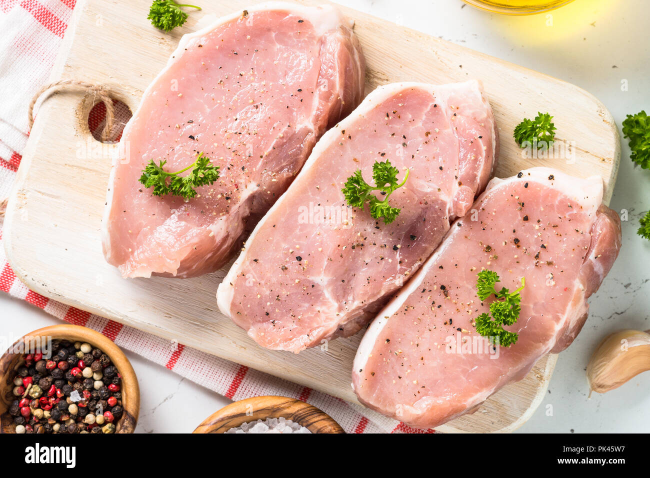 Pork meat steak, slices pork loin on white with herbs and spices. Top ...