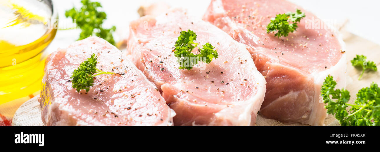 Pork meat steak, slices pork loin on white with herbs and spices. Long ...
