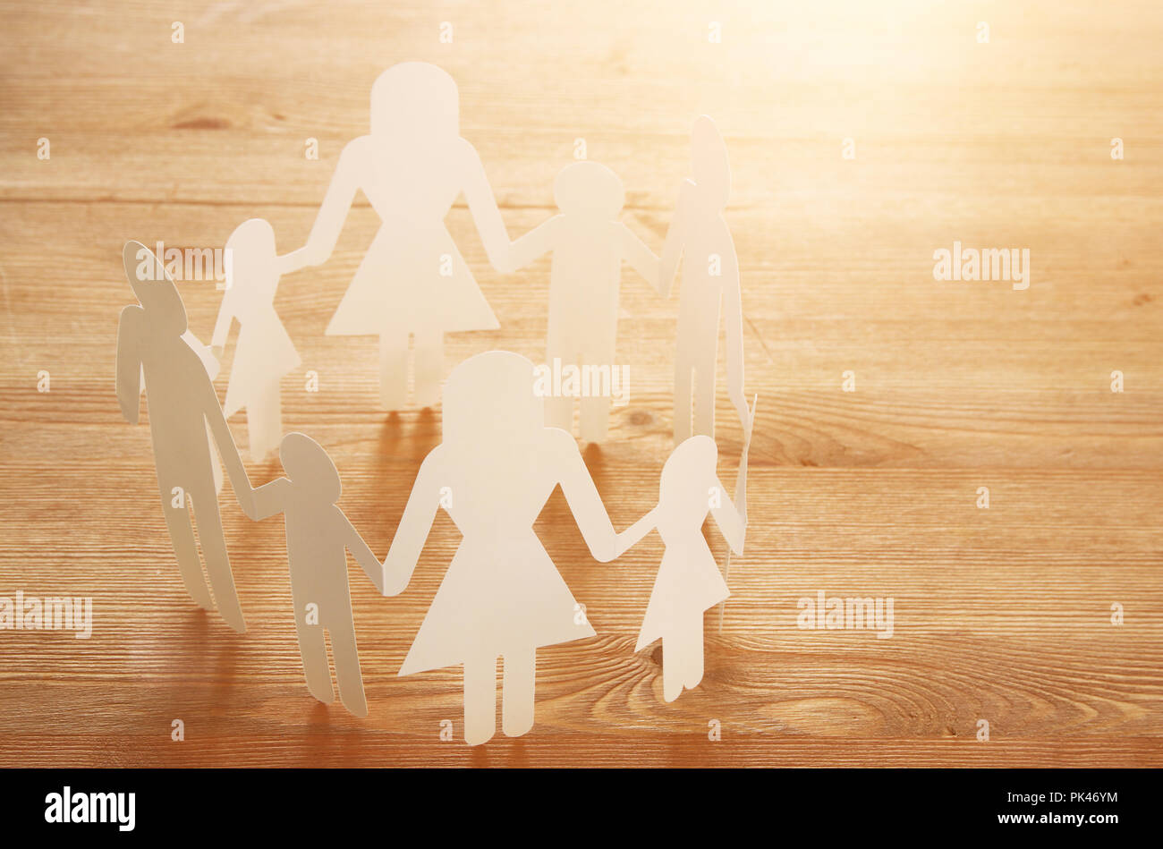 concept image of Family paper chain cutout holding hands, over wooden ...