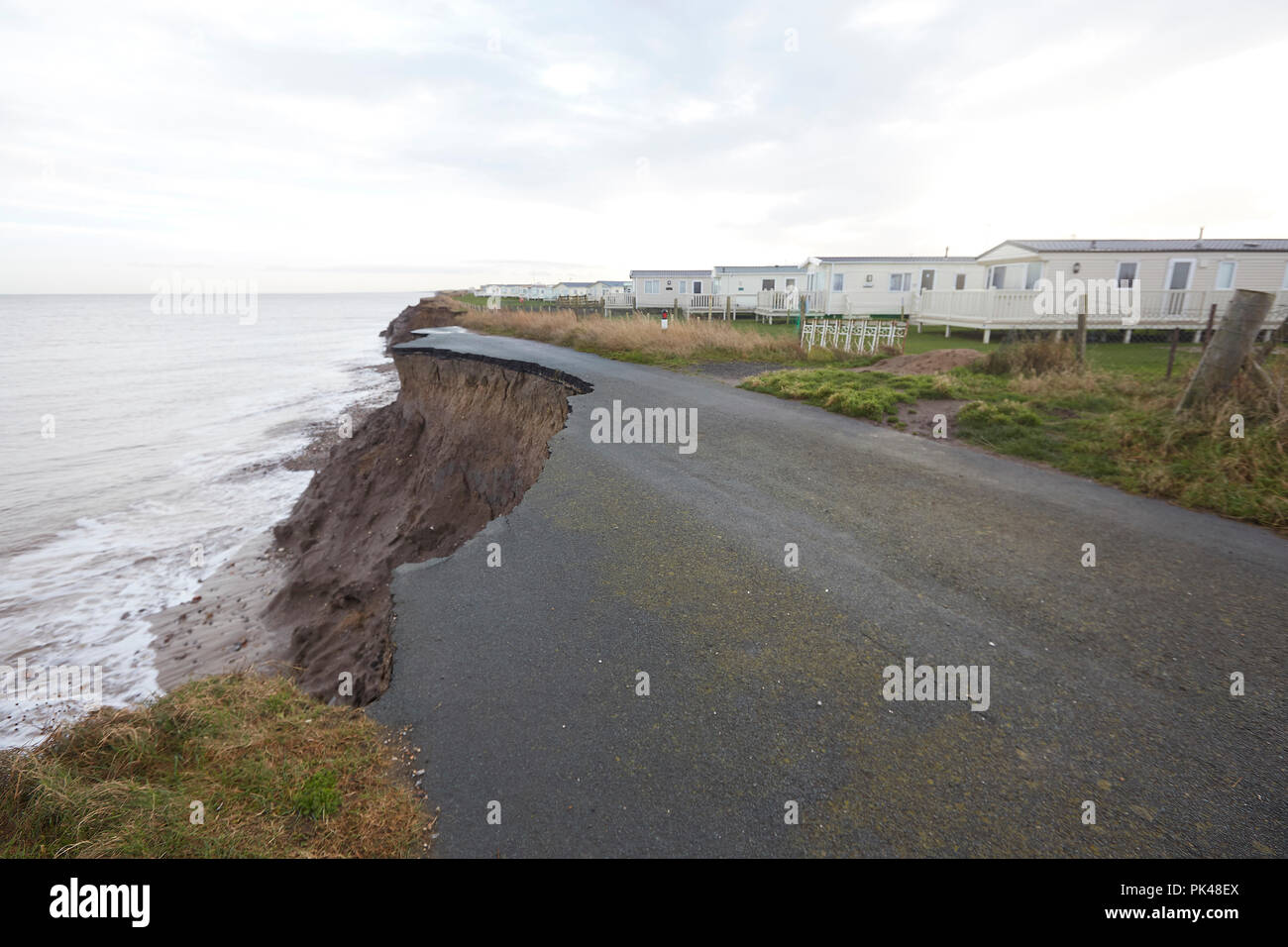 End of the road. Coastal Erosion cliffs, caravans and road collapsing ...