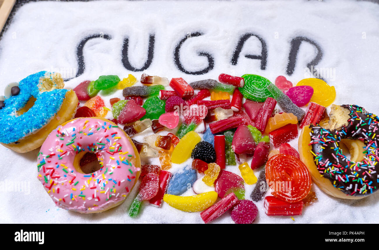 Mix of tempting sweet cakes, donuts and candy with sugar spread and ...