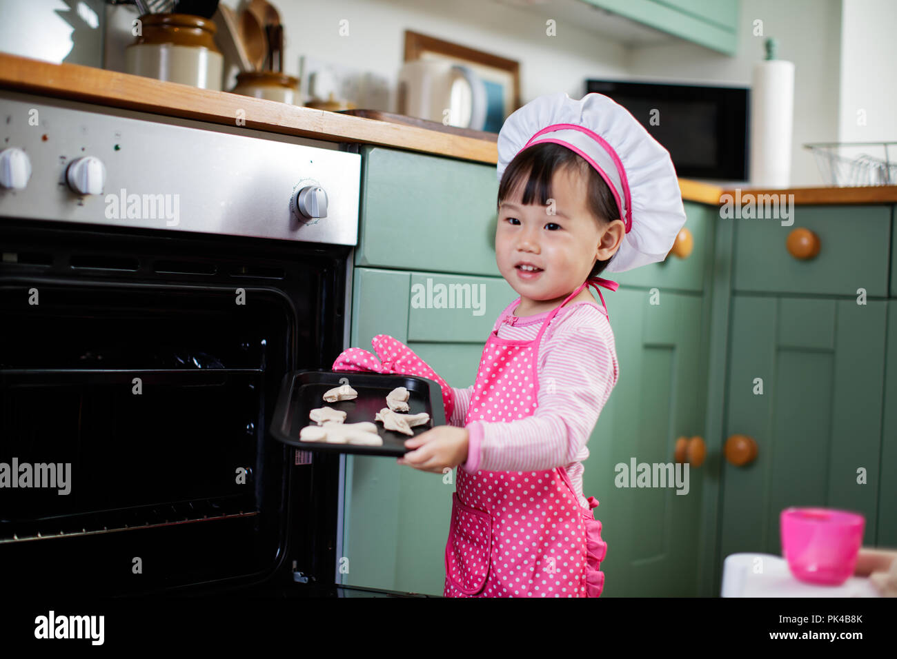 baby girl pretend play baking ginger man bread Stock Photo - Alamy