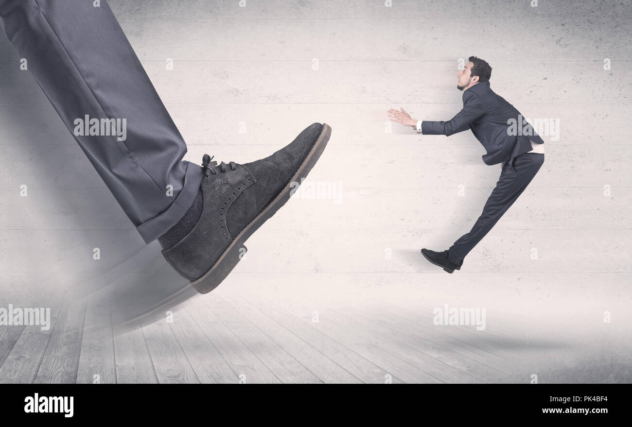 Big foot in a black shoe fire small, young, businessman who is flying ...