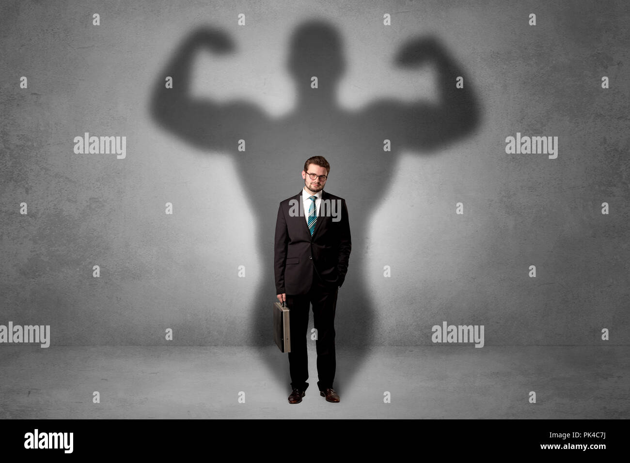 Lovely serious businessman standing with a muscular powerful shadow ...
