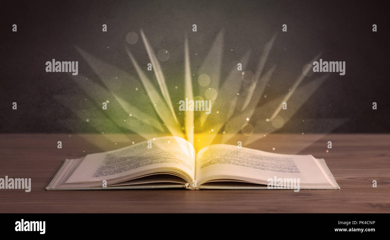 Yellow lights spreading from an open book Stock Photo - Alamy