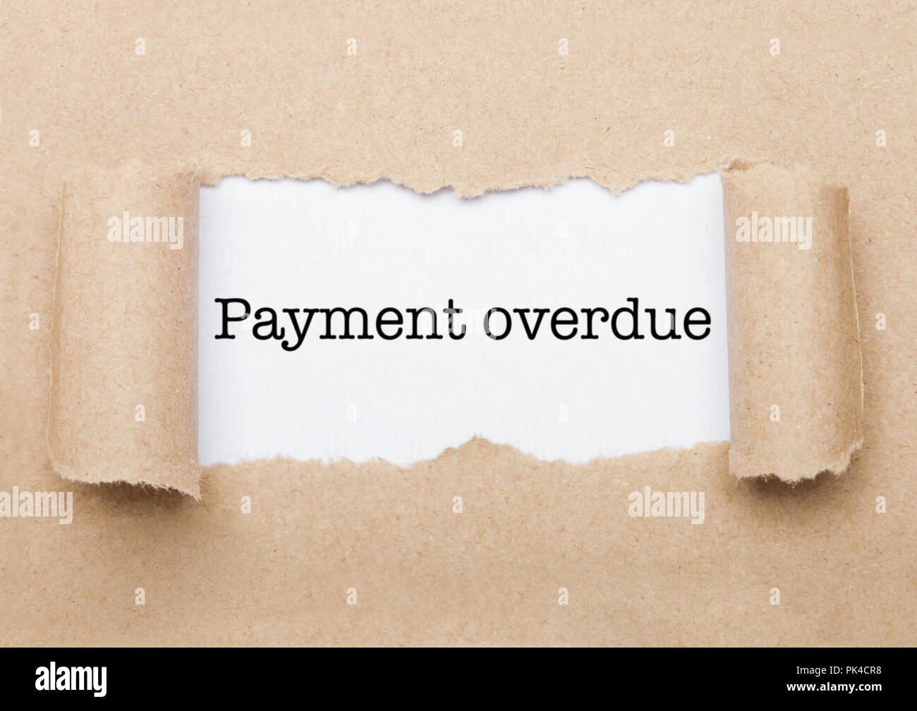 Payment Overdue concept text appearing behind torn brown paper envelope ...