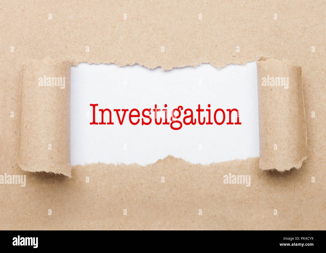 Investigation concept text appearing behind torn brown paper envelope ...