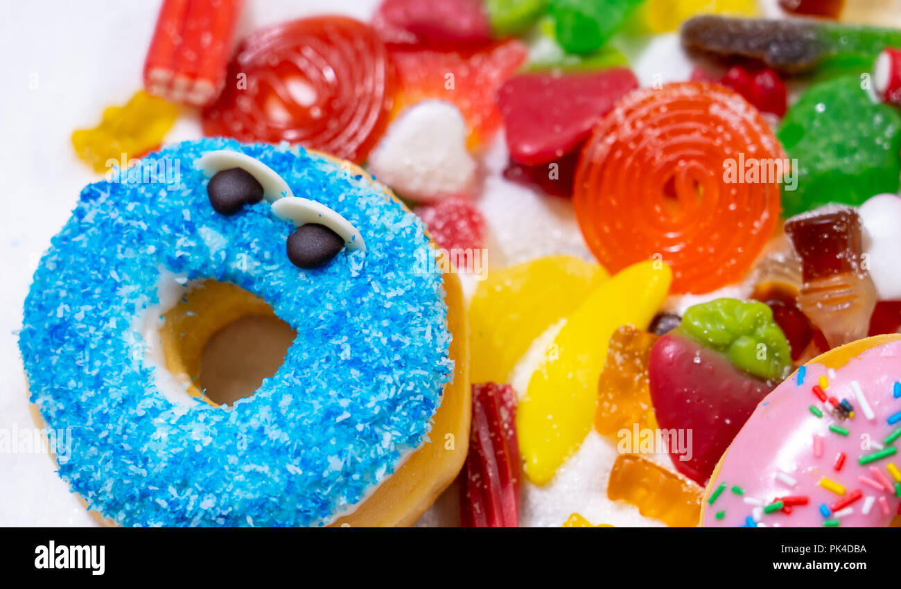 Mix of tempting sweet cakes, donuts and candy with sugar spread in ...