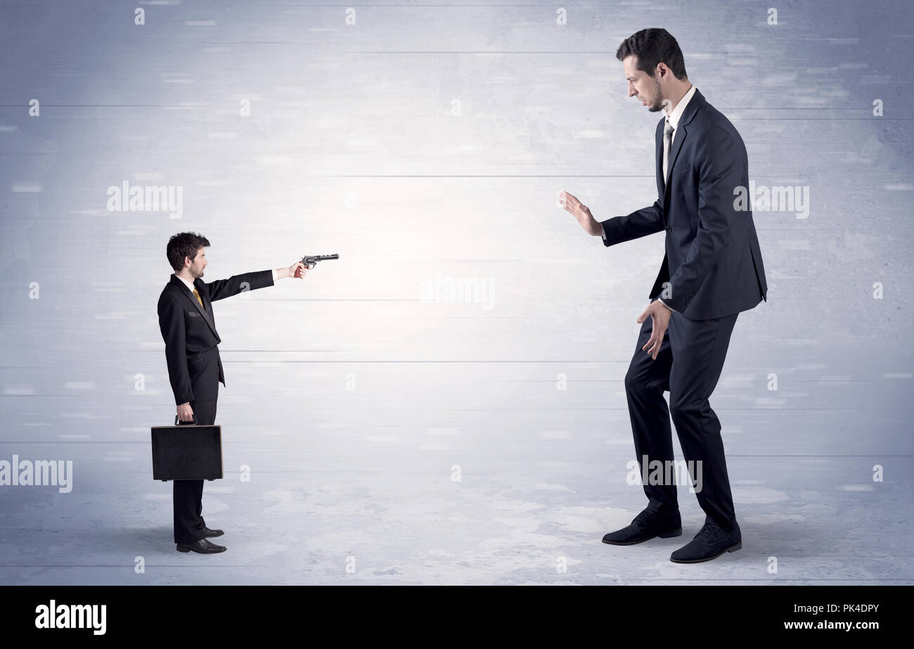 Tiny businessman with gun shooting giant fearful businessman Stock ...