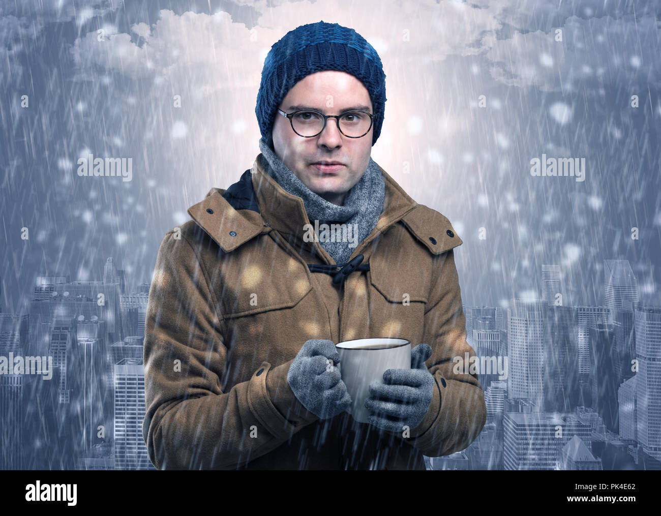 Young man freezing in warm clothing with city concept Stock Photo - Alamy