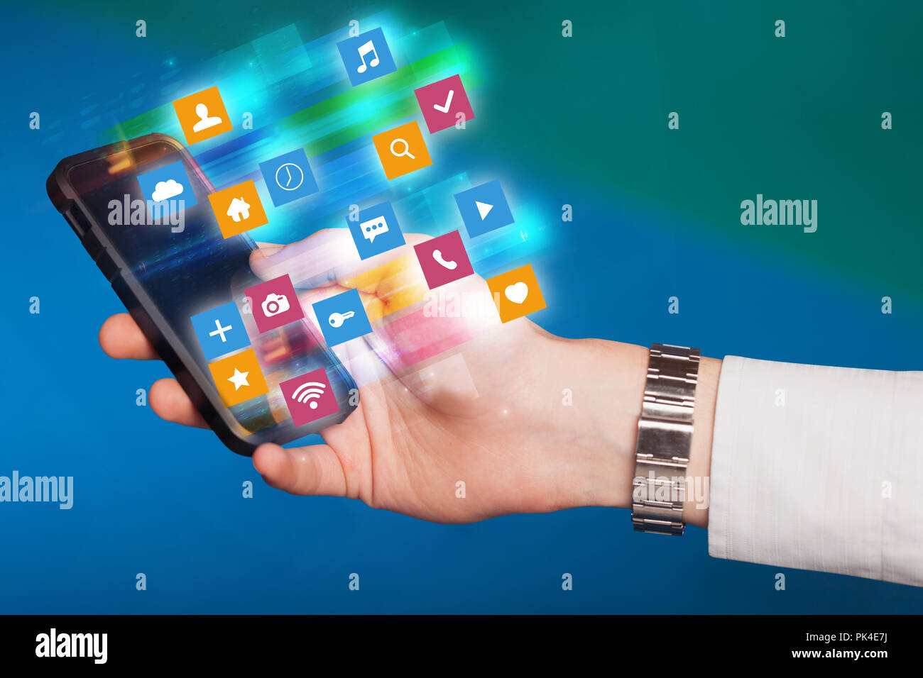 Hand using phone with colorful fast moving application icons and ...