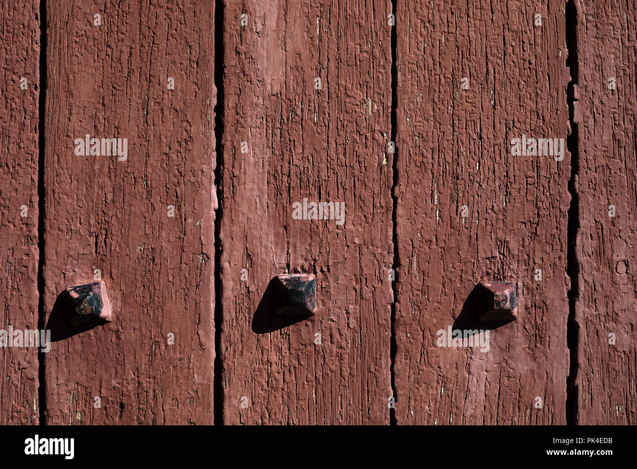 Old wood door detail red, brown and black nails Stock Photo - Alamy