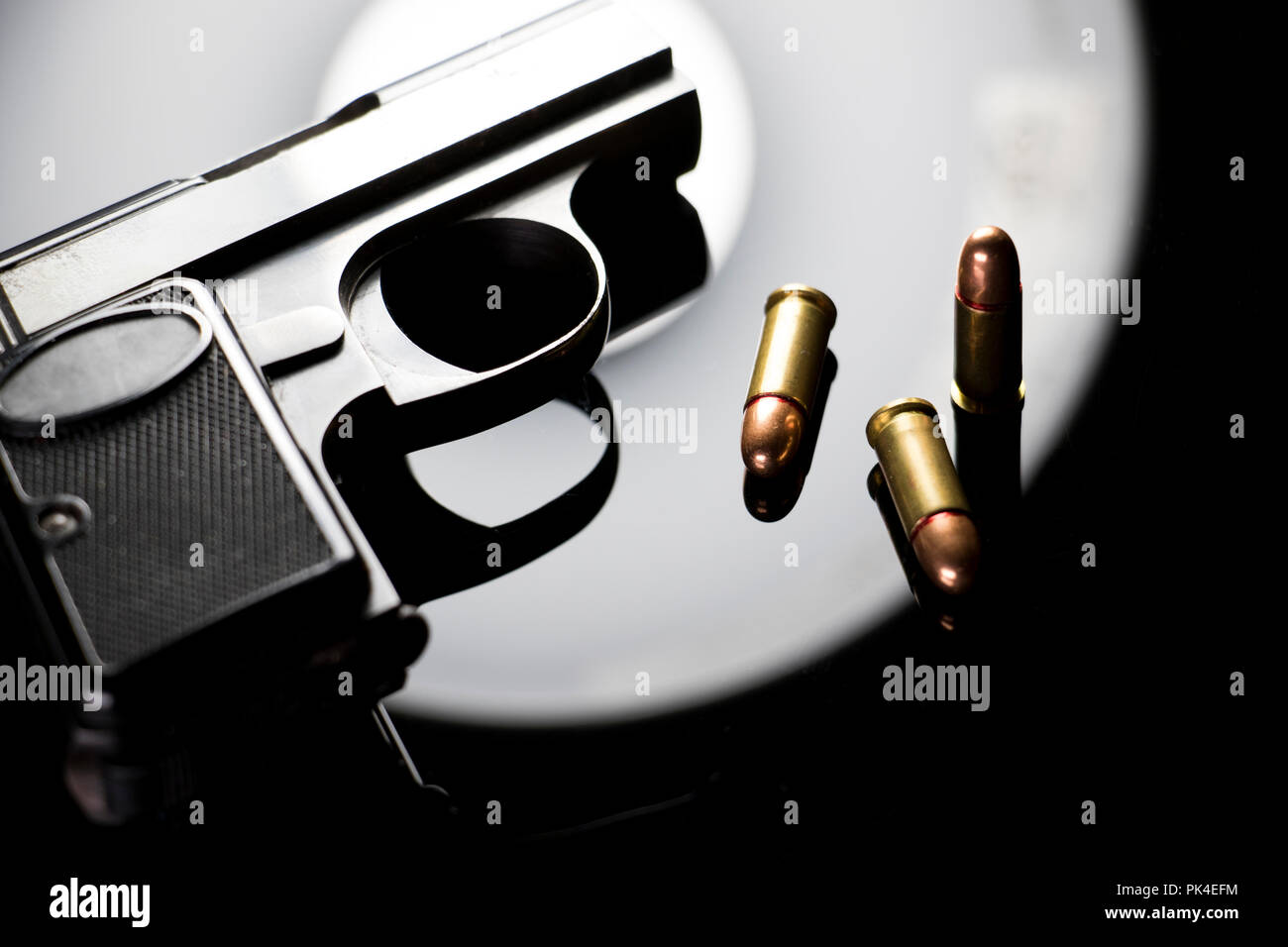 Gun and Bullets on a glass table. Handgun and ammunition Stock Photo ...