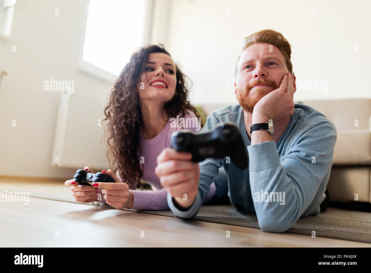 Happy couple playing video games at home Stock Photo - Alamy