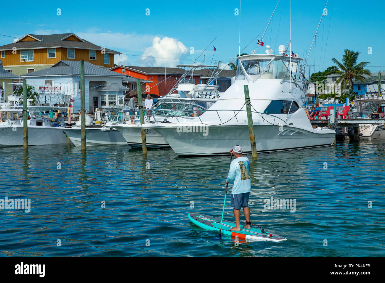 Tourist paddleboarding at Marina dock at Rosie’s Place in Grand Cay ...
