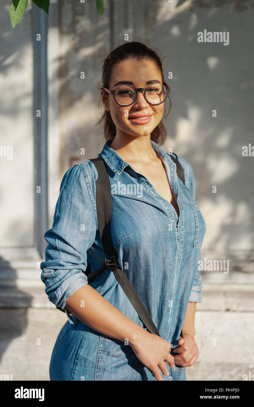 Young attractive bespectacled woman looking at the camera and smiling ...