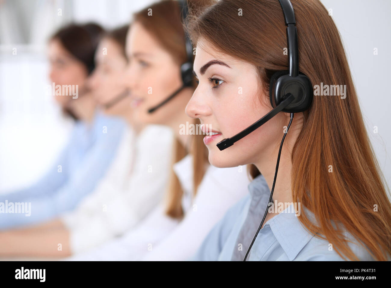 Call center. Beautiful cheerful smiling operator consulting clients ...