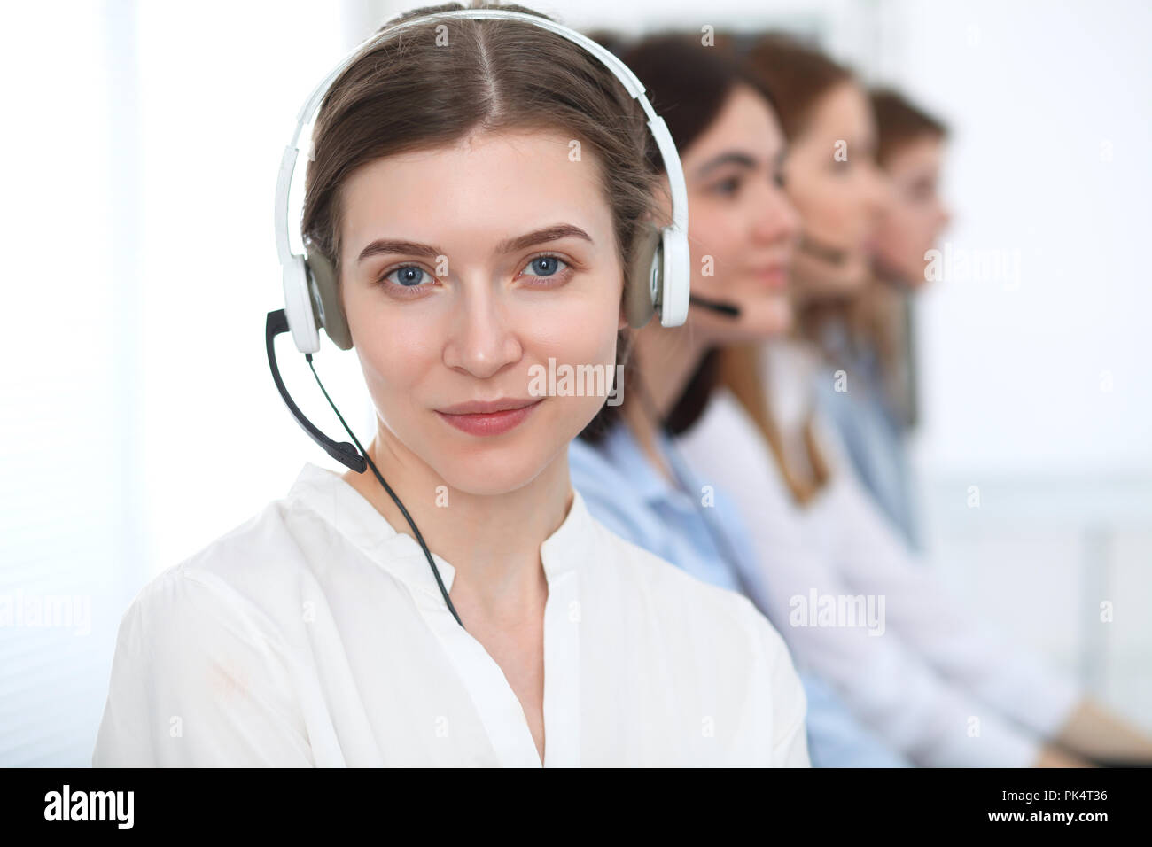 Call center. Beautiful cheerful smiling operator consulting clients ...