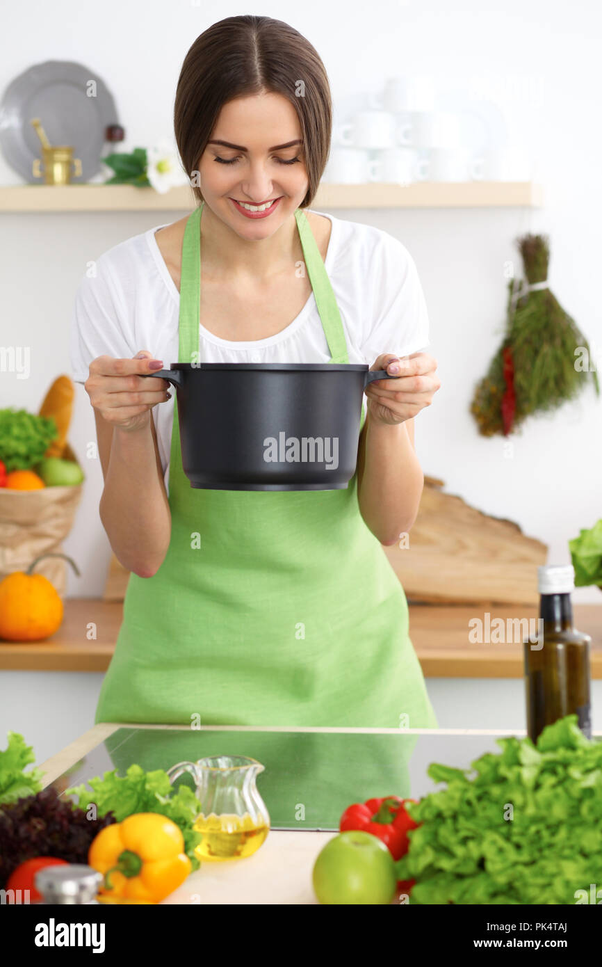 Beautiful Hispanic woman cooking soup in kitchen. Healthy meal and ...