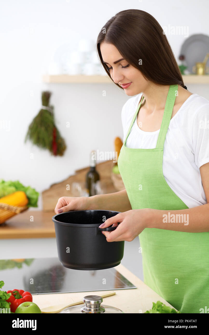 Beautiful Hispanic woman cooking soup in kitchen. Healthy meal and ...
