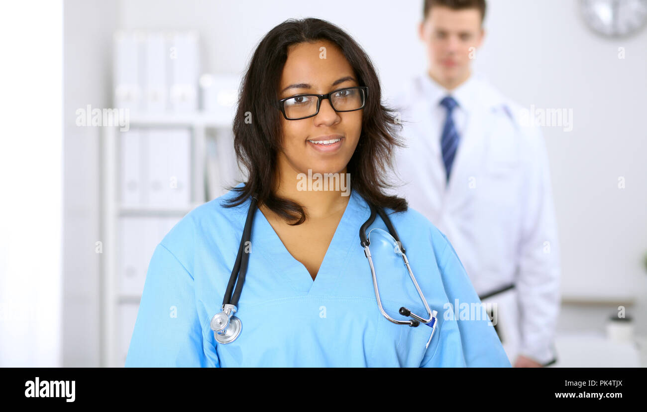 Female african american medical doctor with colleagues in background at ...