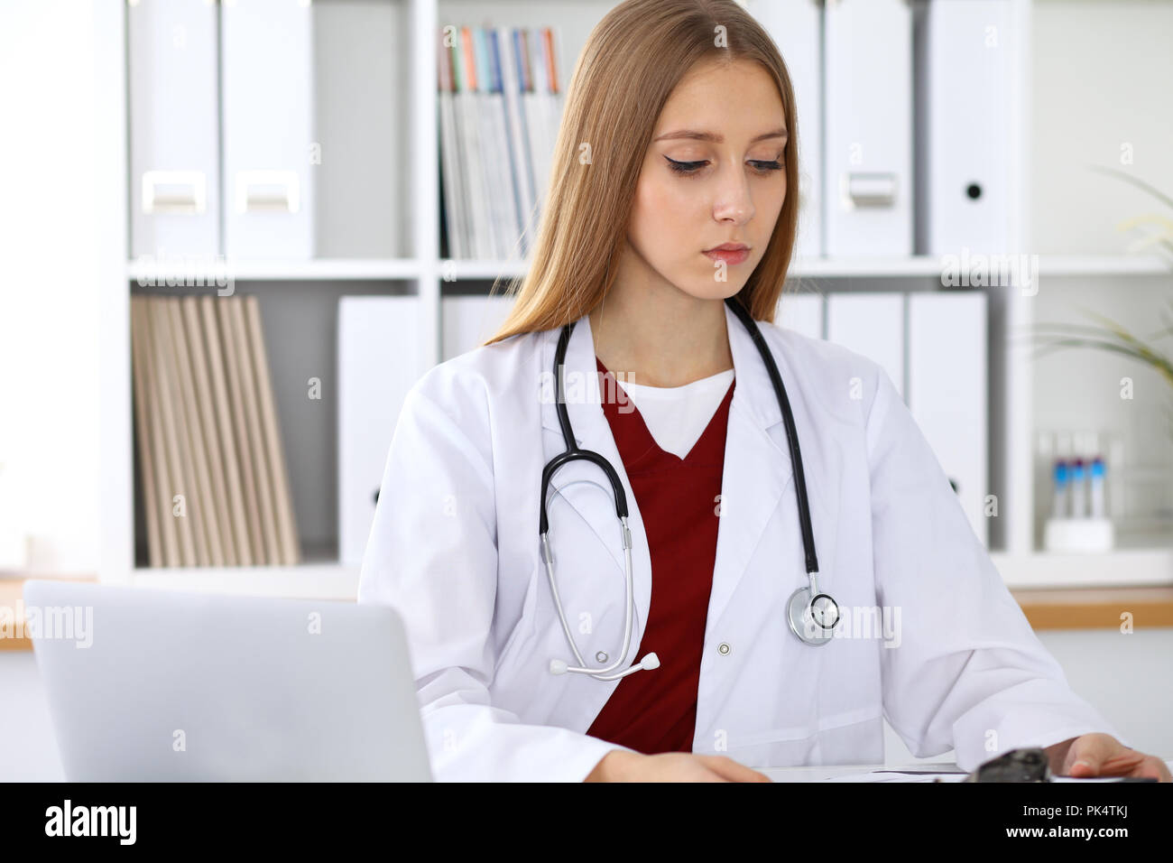 Brunette female doctor using laptop computer in hospital. Healthcare ...