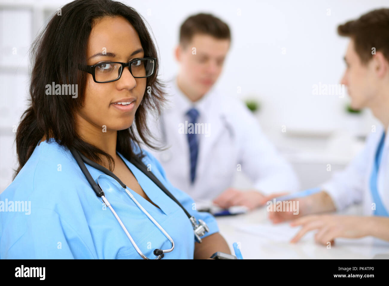 Female african american medical doctor with colleagues in background at ...