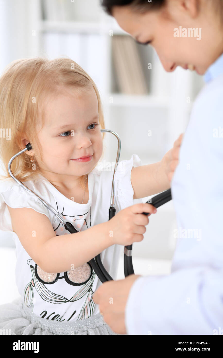 Doctor and patient baby in hospital. Little girl is being examined by ...