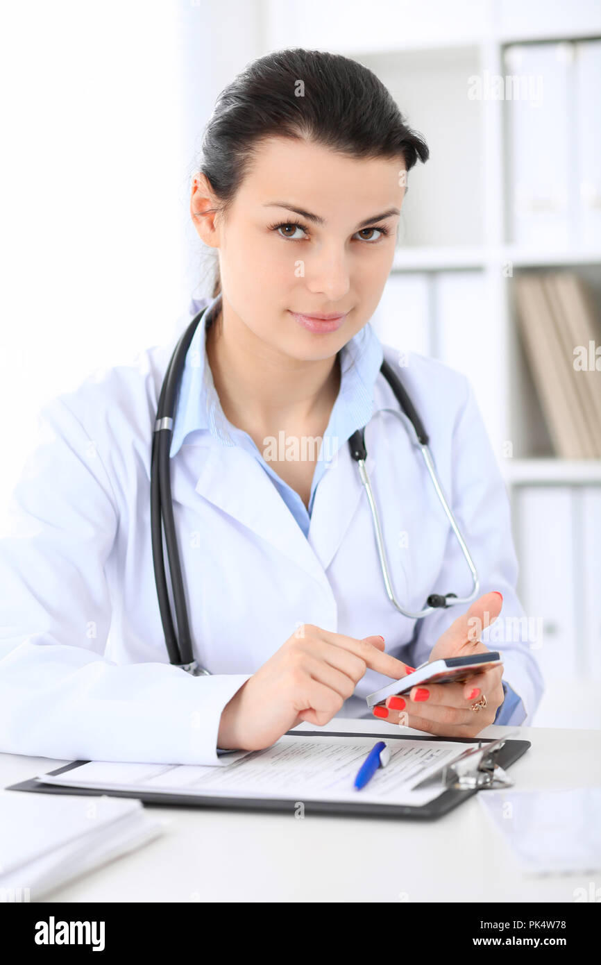 Young brunette female doctor at working place in hospital. Health care ...