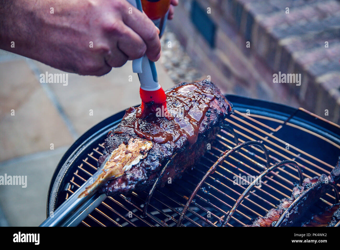Cooking marinated baby back ribs on an outdoor barbecue Stock Photo - Alamy