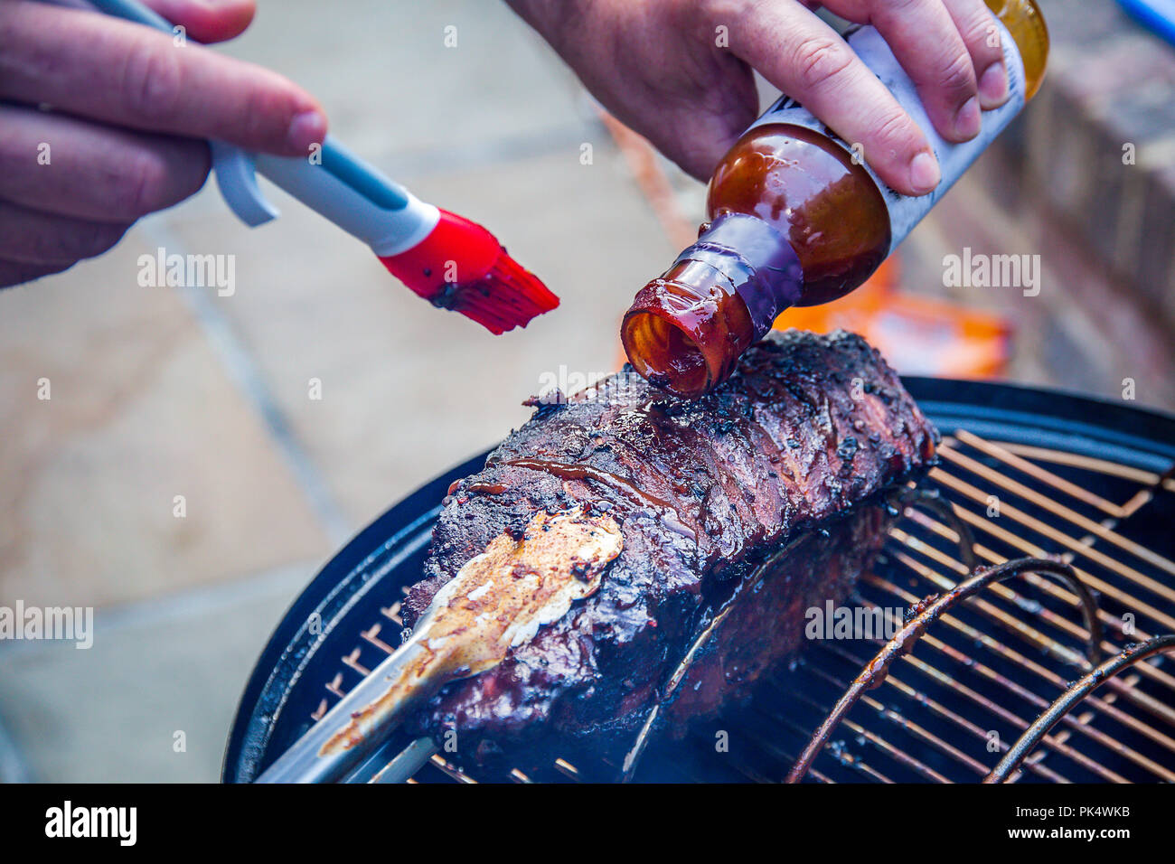 Cooking marinated baby back ribs on an outdoor barbecue Stock Photo - Alamy