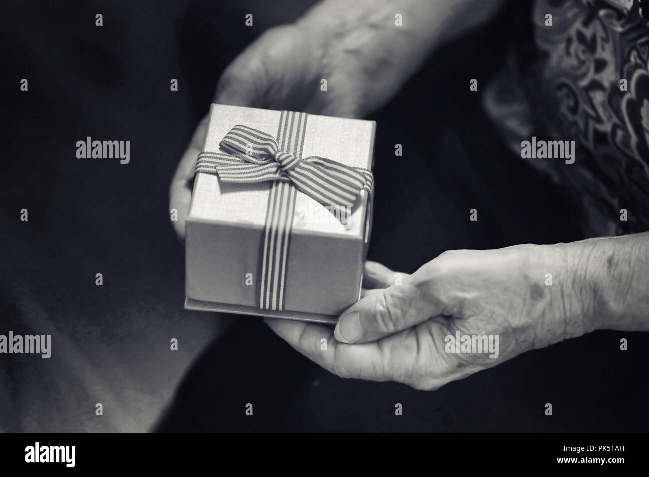 elder woman holding gift Stock Photo - Alamy