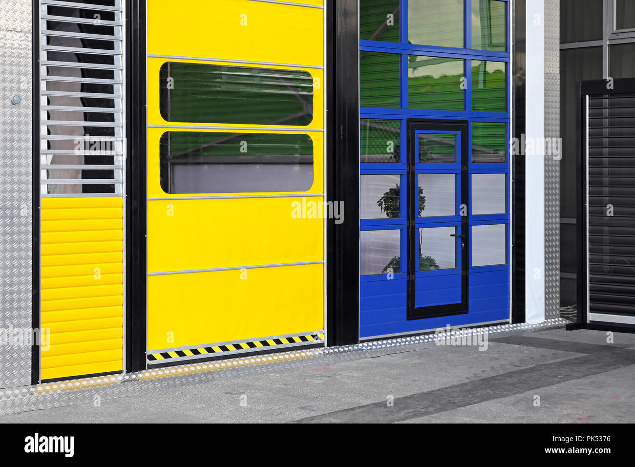 Tall doors at distribution warehouse building Stock Photo - Alamy