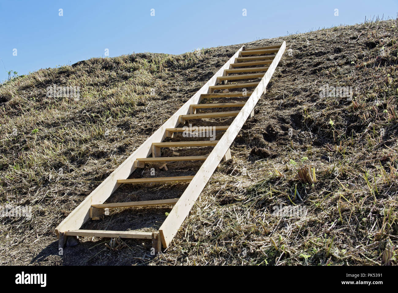 A clumsy wooden ladder lying on an earthen hill. Conceptual - movement ...