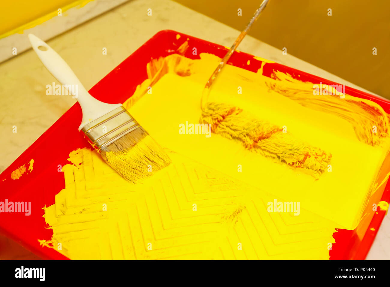Bucket with yellow color and with the brush and paint roller ready for ...