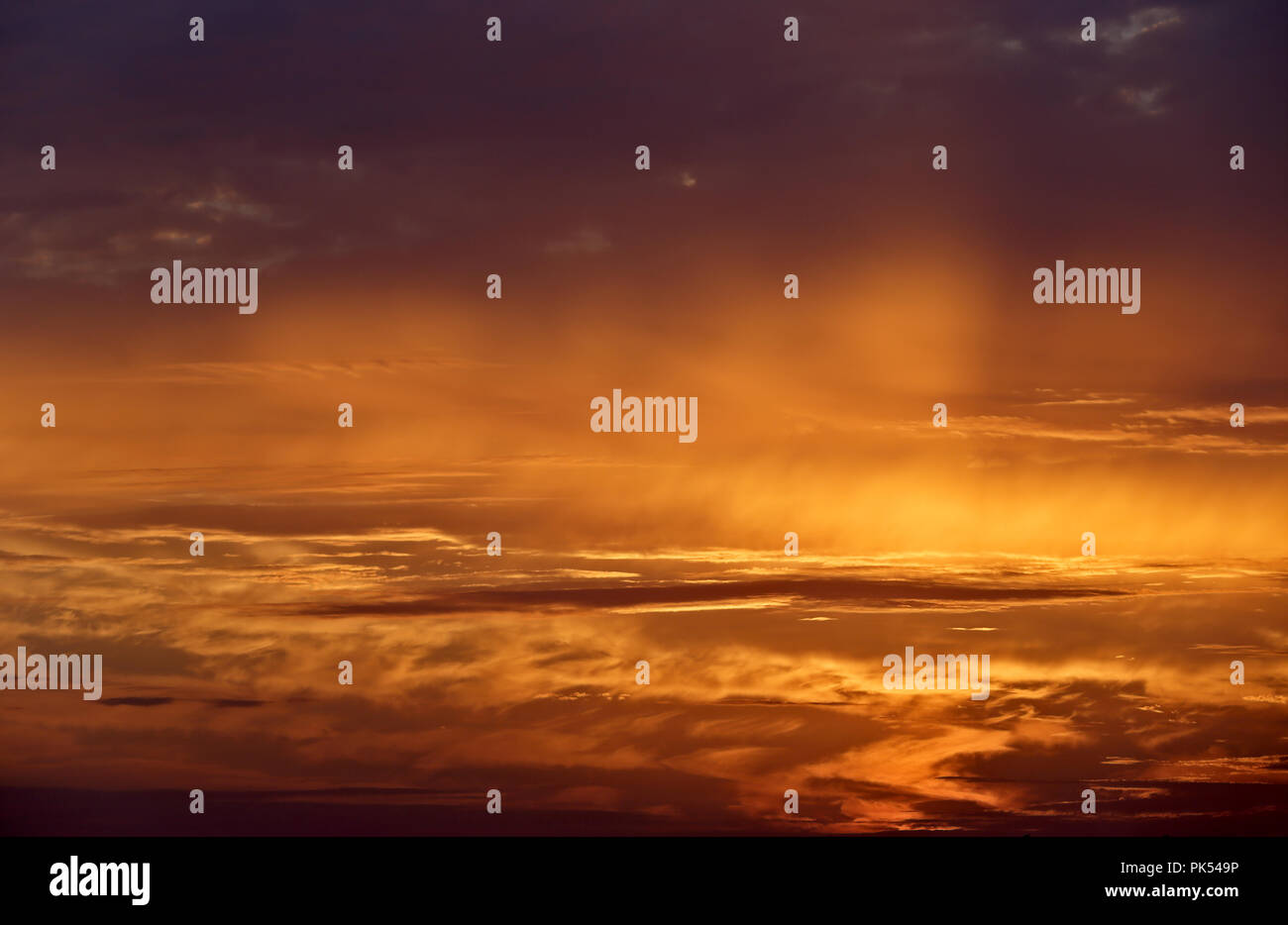 Sun sending its last rays to the clouds in autumn evening Stock Photo ...