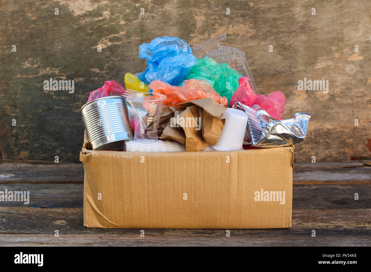 Box with trash on wooden background Stock Photo - Alamy