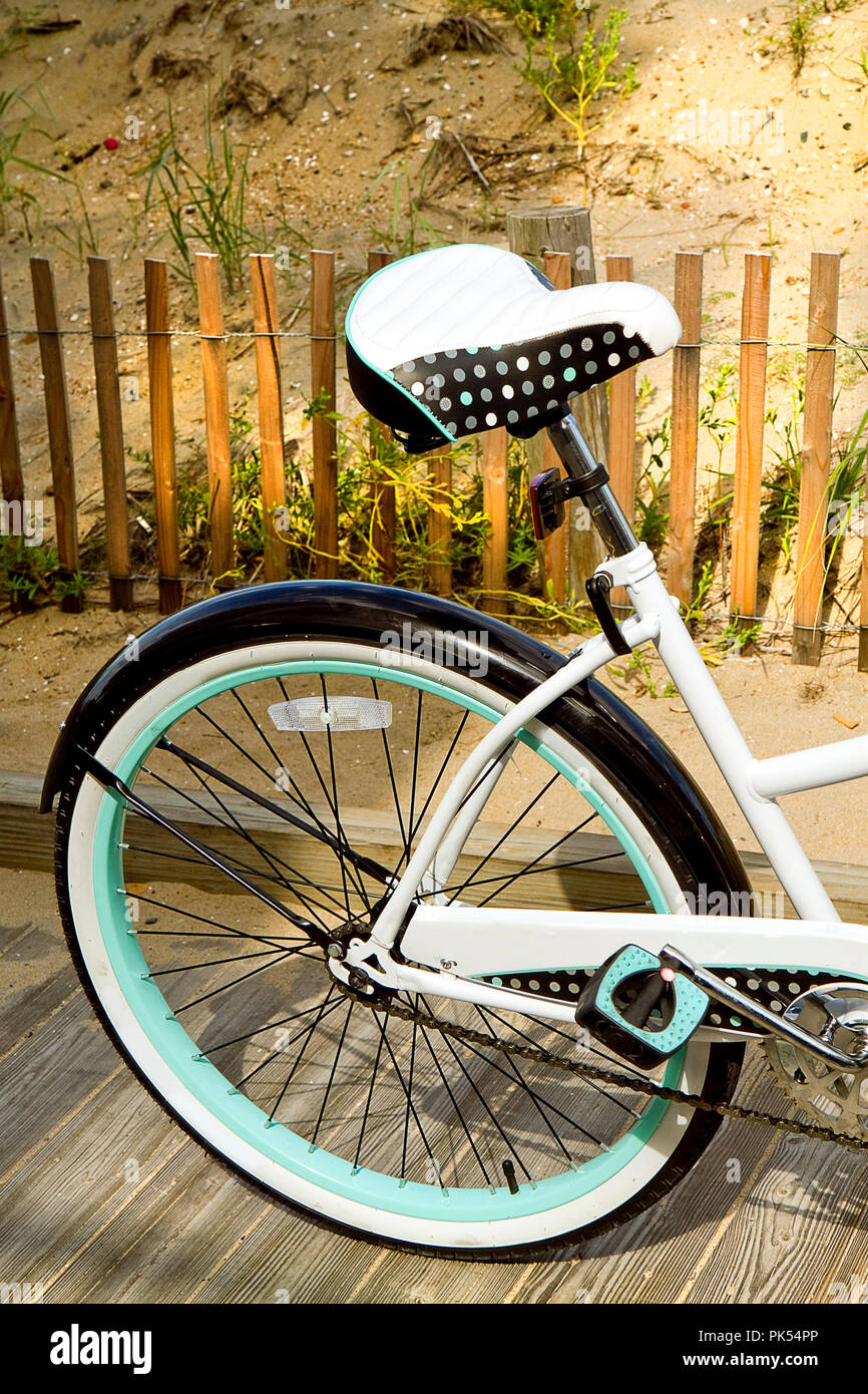 Partial view of backside of bike at the beach with fence and view of ...