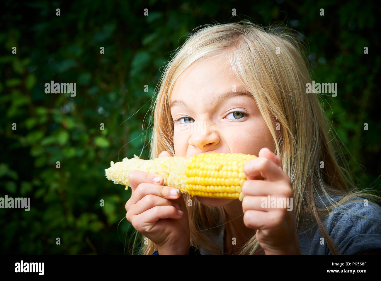 Portrait of girl eating sweet boiled sweet corn outdoor Stock Photo - Alamy
