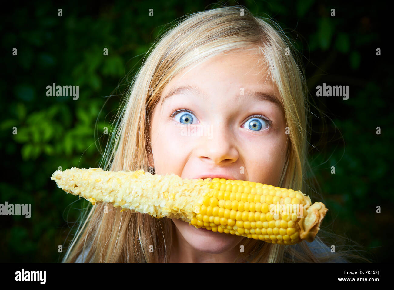 Portrait of girl eating sweet boiled sweet corn outdoor Stock Photo - Alamy