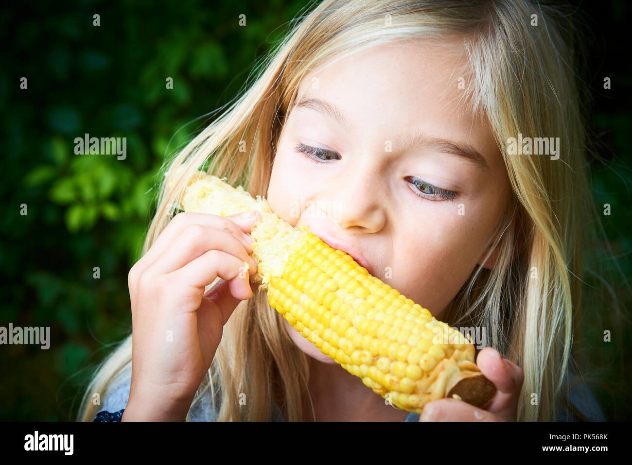 Portrait of girl eating sweet boiled sweet corn outdoor Stock Photo - Alamy