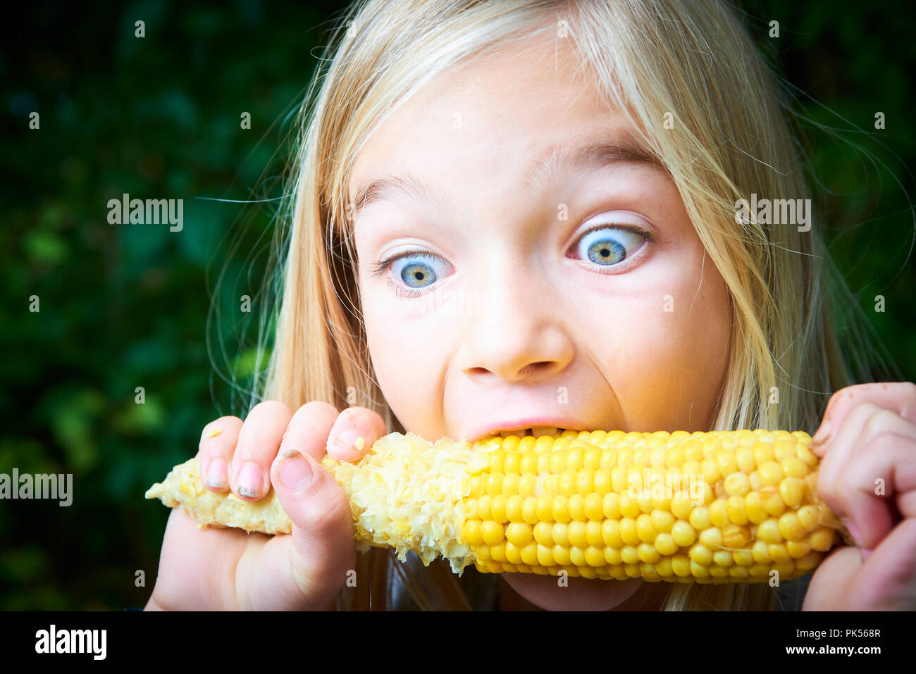 Portrait of girl eating sweet boiled sweet corn outdoor Stock Photo - Alamy